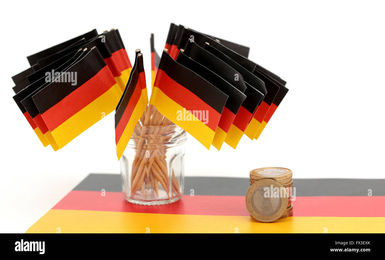 Little German flags next to a pile of euro's on top of a German flag ...