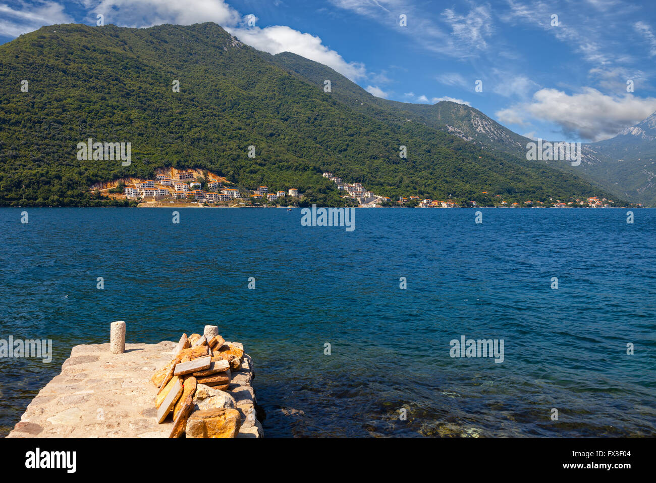 Stone wharf against the sea and mountains, Bay of Kotor, Montenegro ...