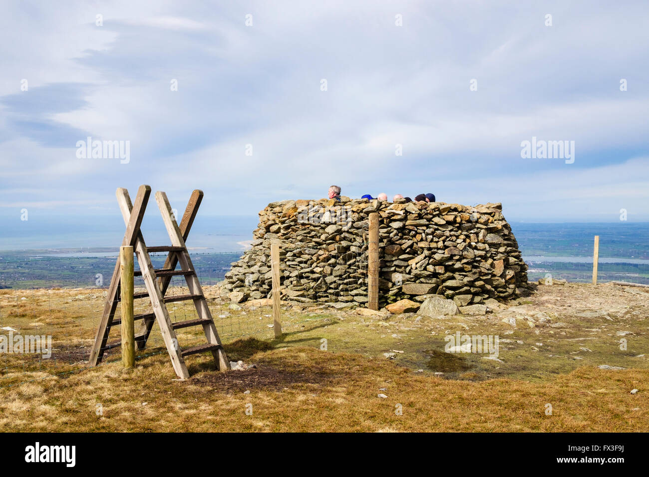 Hikers sheltering inside stone shelter on Moel Eilio mountain top in ...