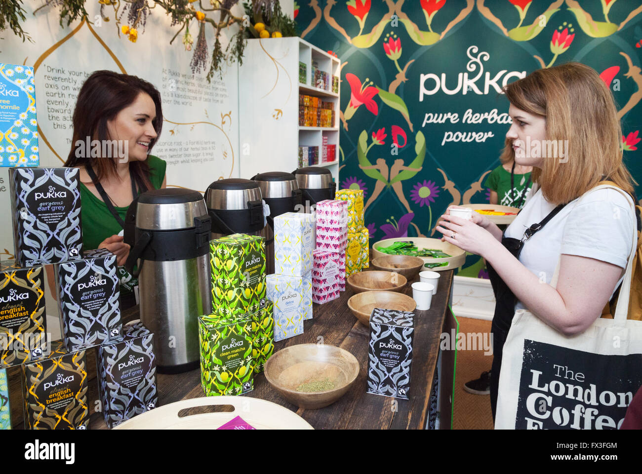 A woman tasting Pukka tea at a Pukka Herbal Tea stall, London UK Stock ...