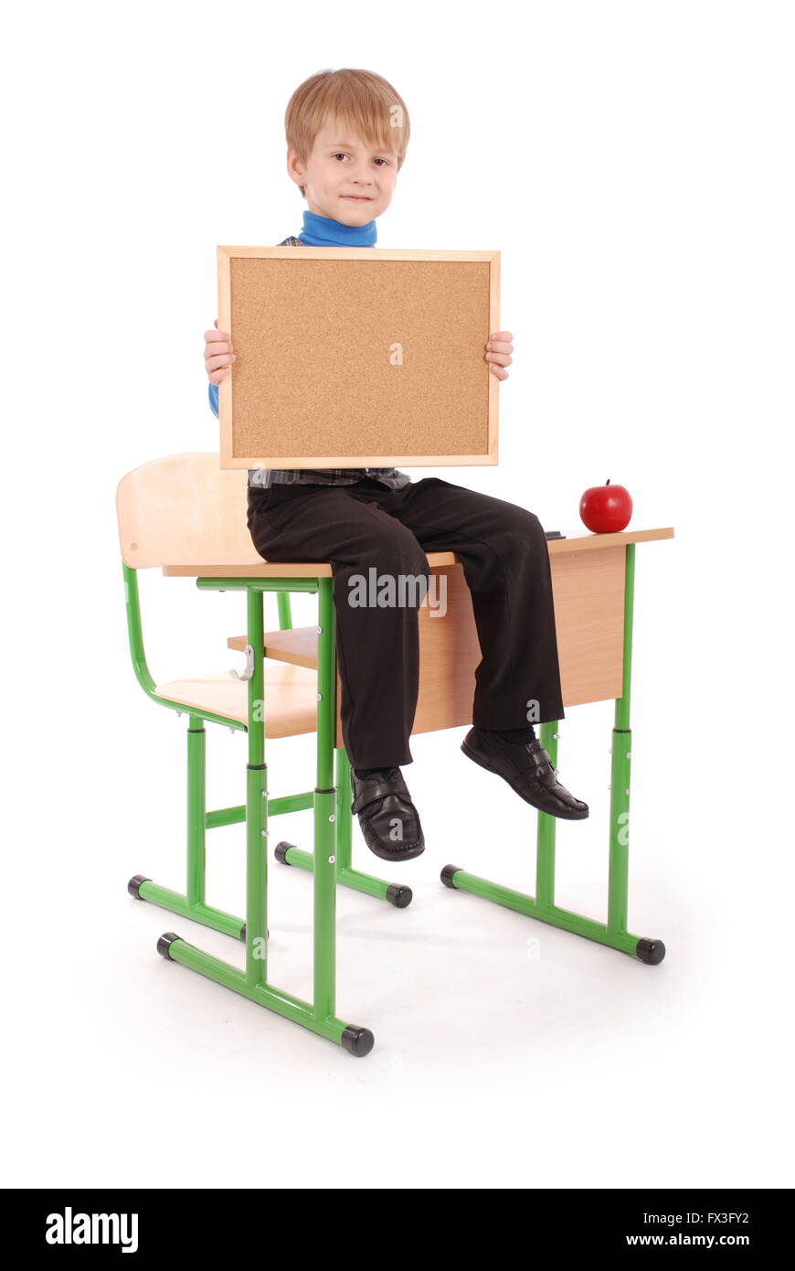 Boy sitting on the school desk and holding board isolated on white ...