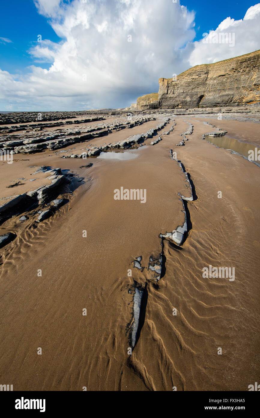 Patterns formed by sand and exposed rock strata in a beach of the ...
