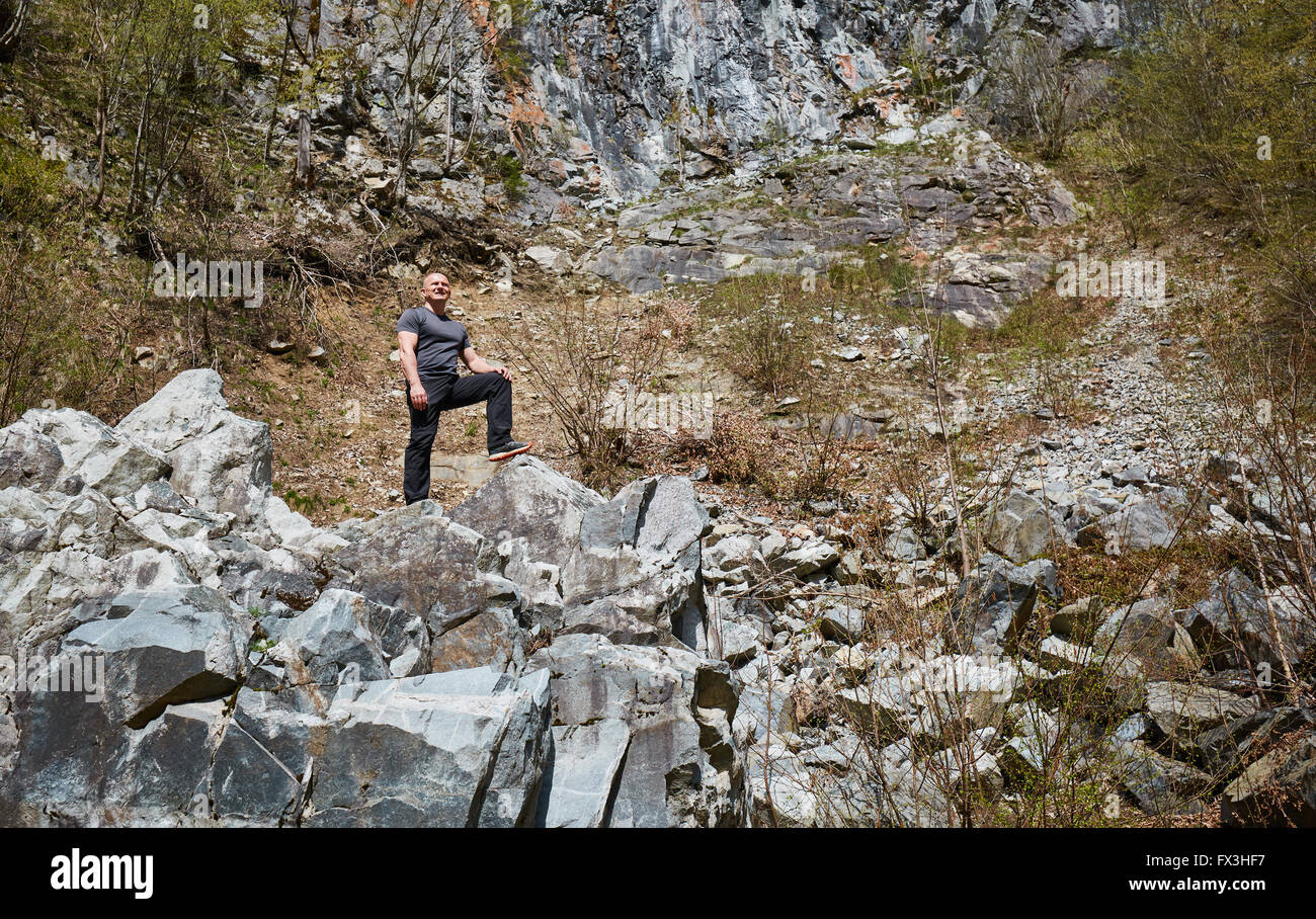 Happy man hiker standing on big stones broke from mountain Stock Photo ...