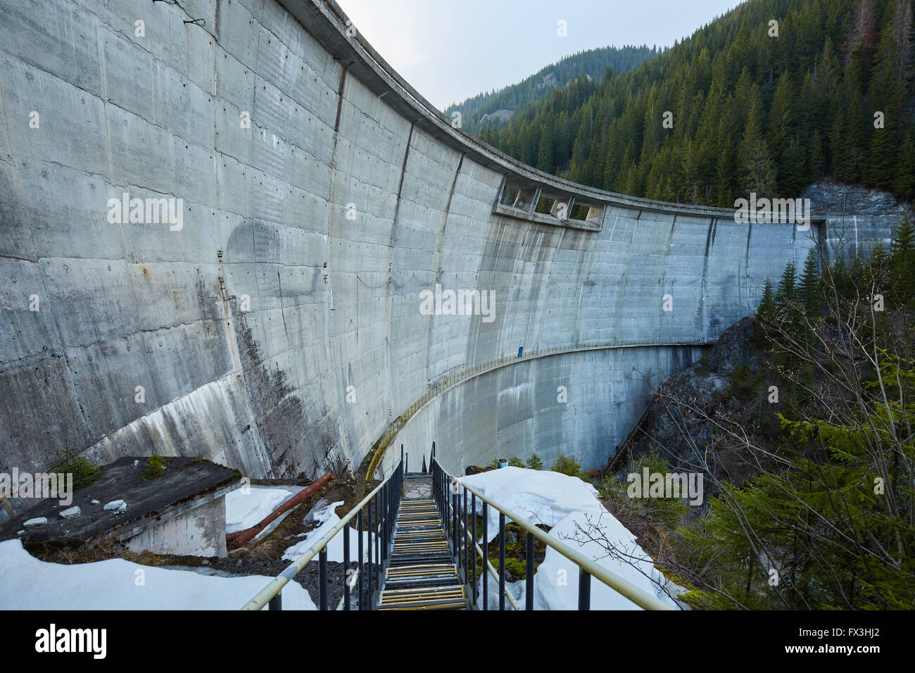 Wide view of a concrete dam in the mountains Stock Photo - Alamy