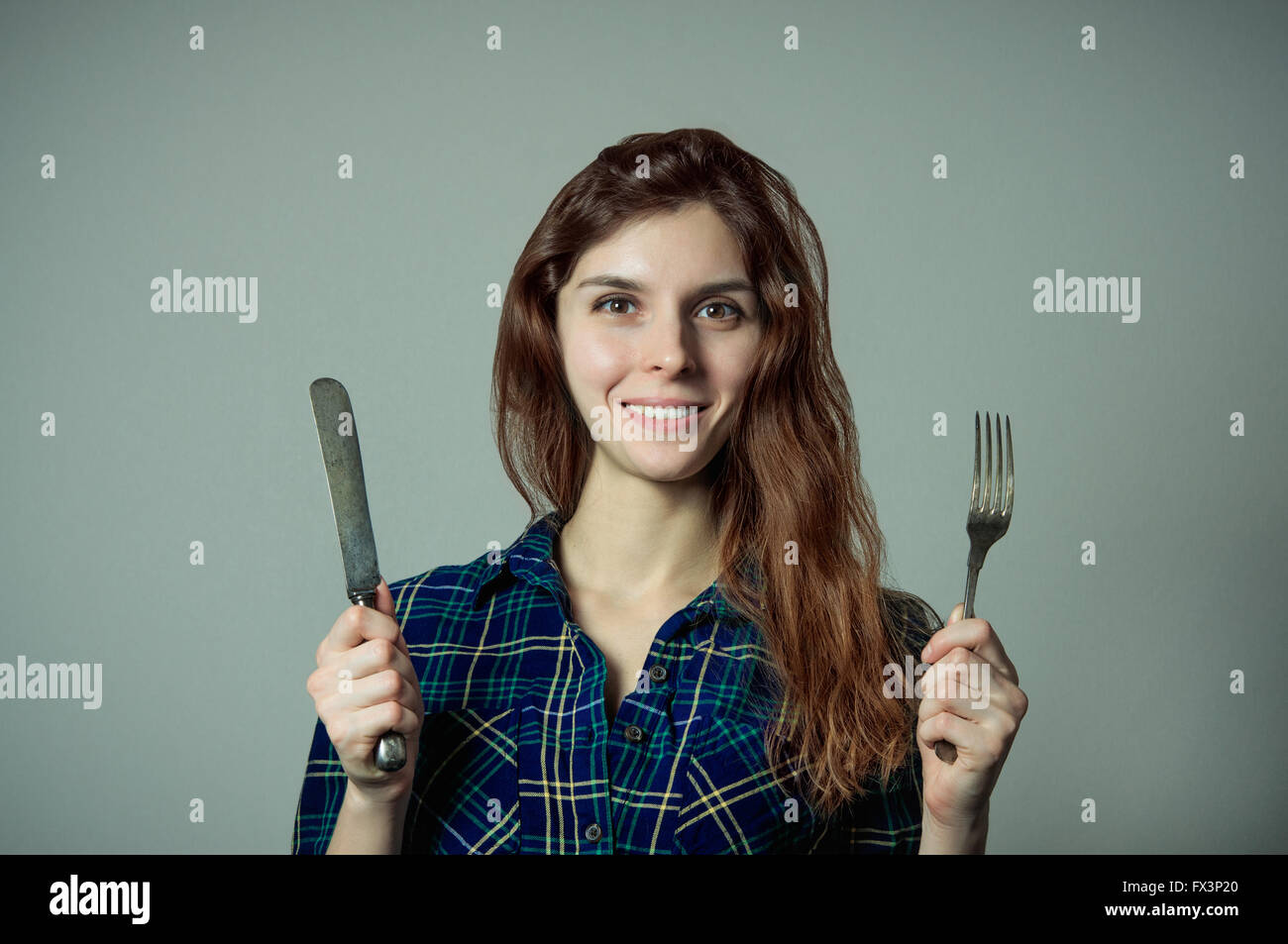 Girl holding up knife fork hi-res stock photography and images - Alamy