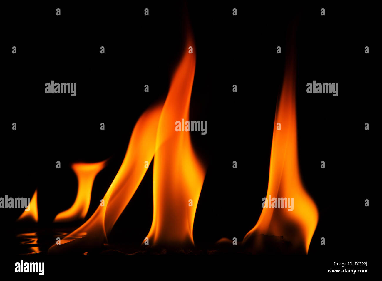 Five flames, two small and three large with a reflection in the ground ...