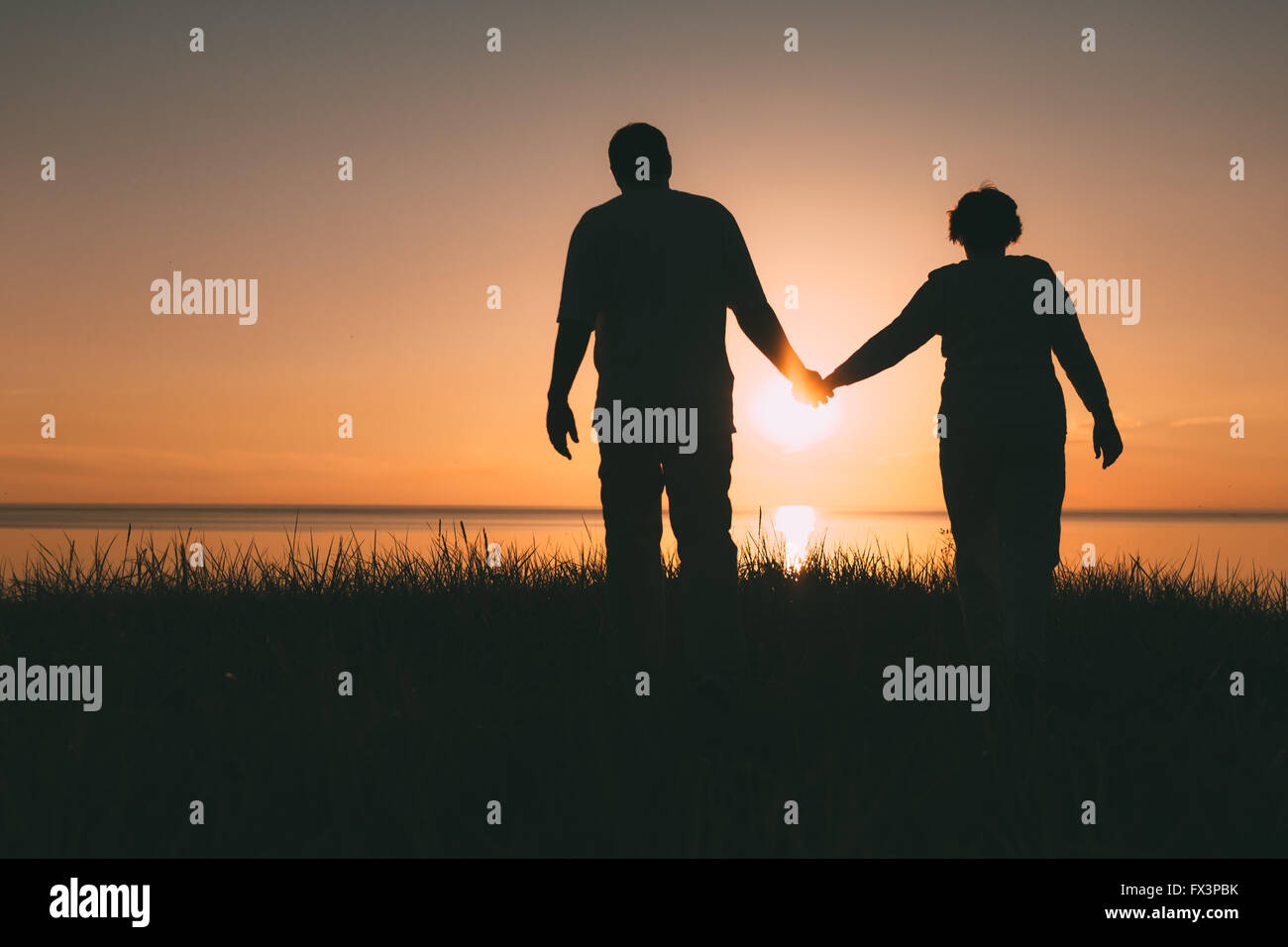 Adult couple silhouettes at sunset Stock Photo - Alamy