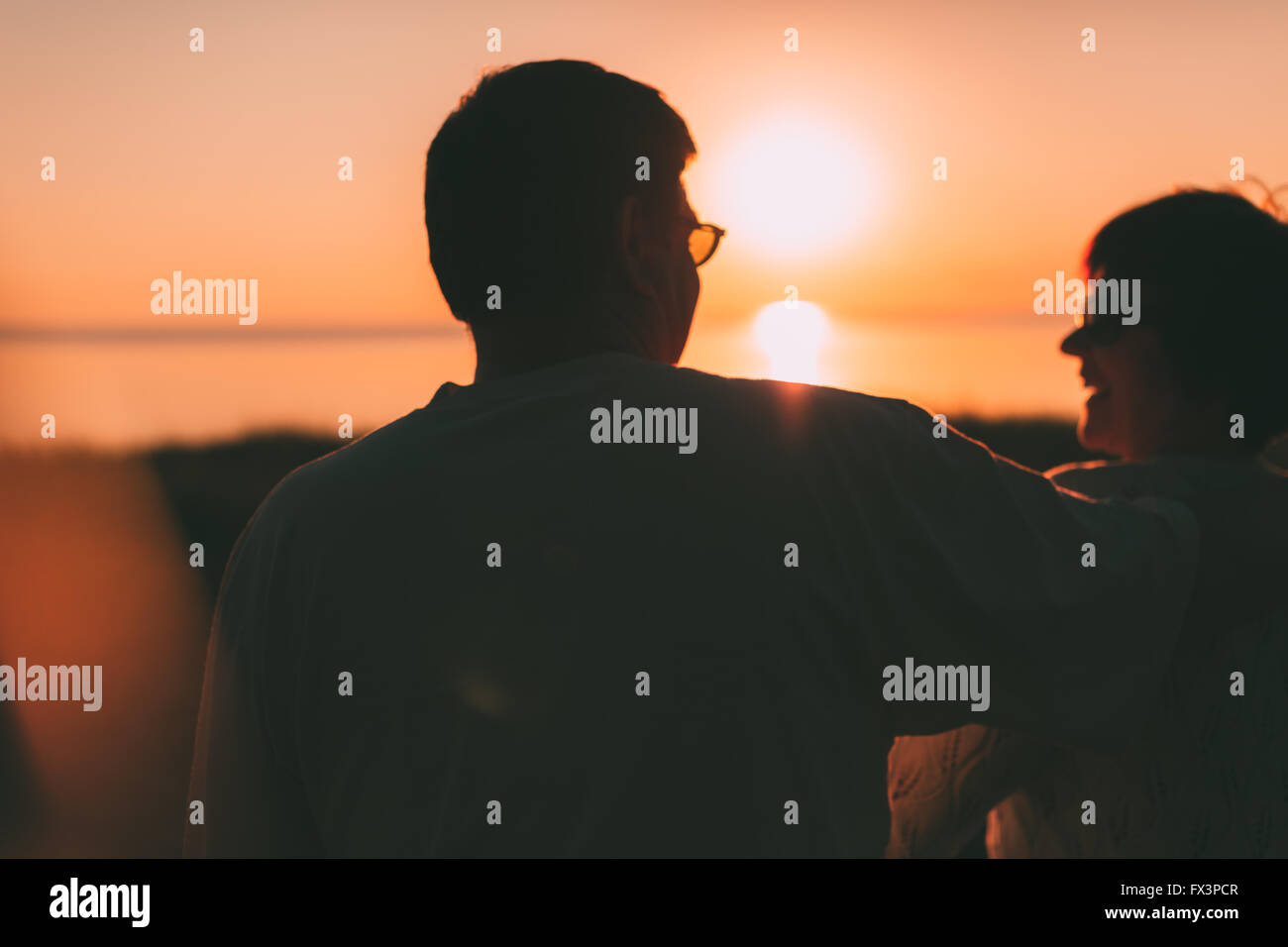 Back view a married couple a silhouette sitting on a bench Stock Photo ...