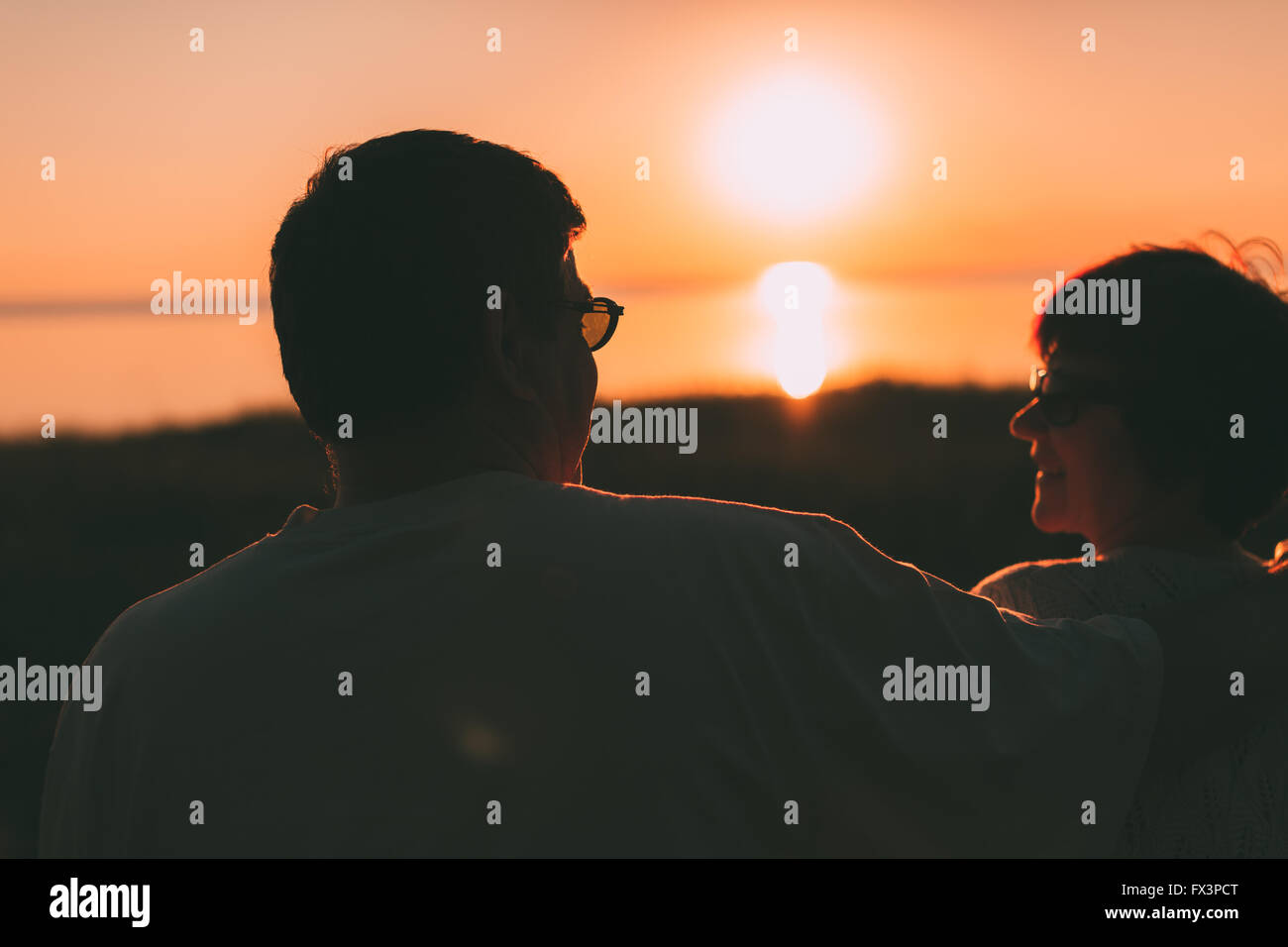 Back view a married couple a silhouette sitting on a bench Stock Photo ...