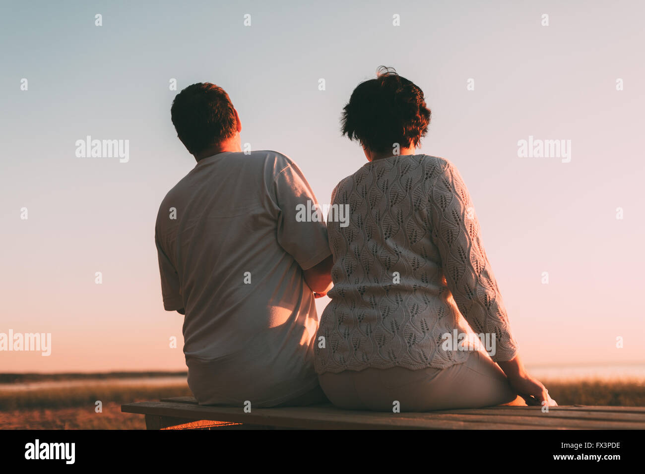 Back view a married couple a silhouette sitting on a bench Stock Photo ...