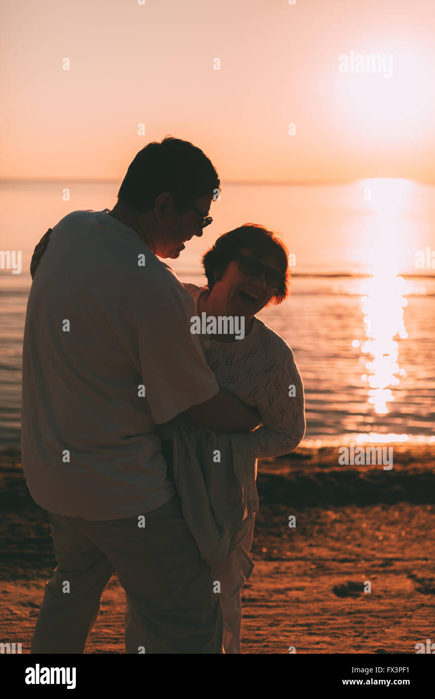 Adult couple embracing at sunset and sea Stock Photo - Alamy