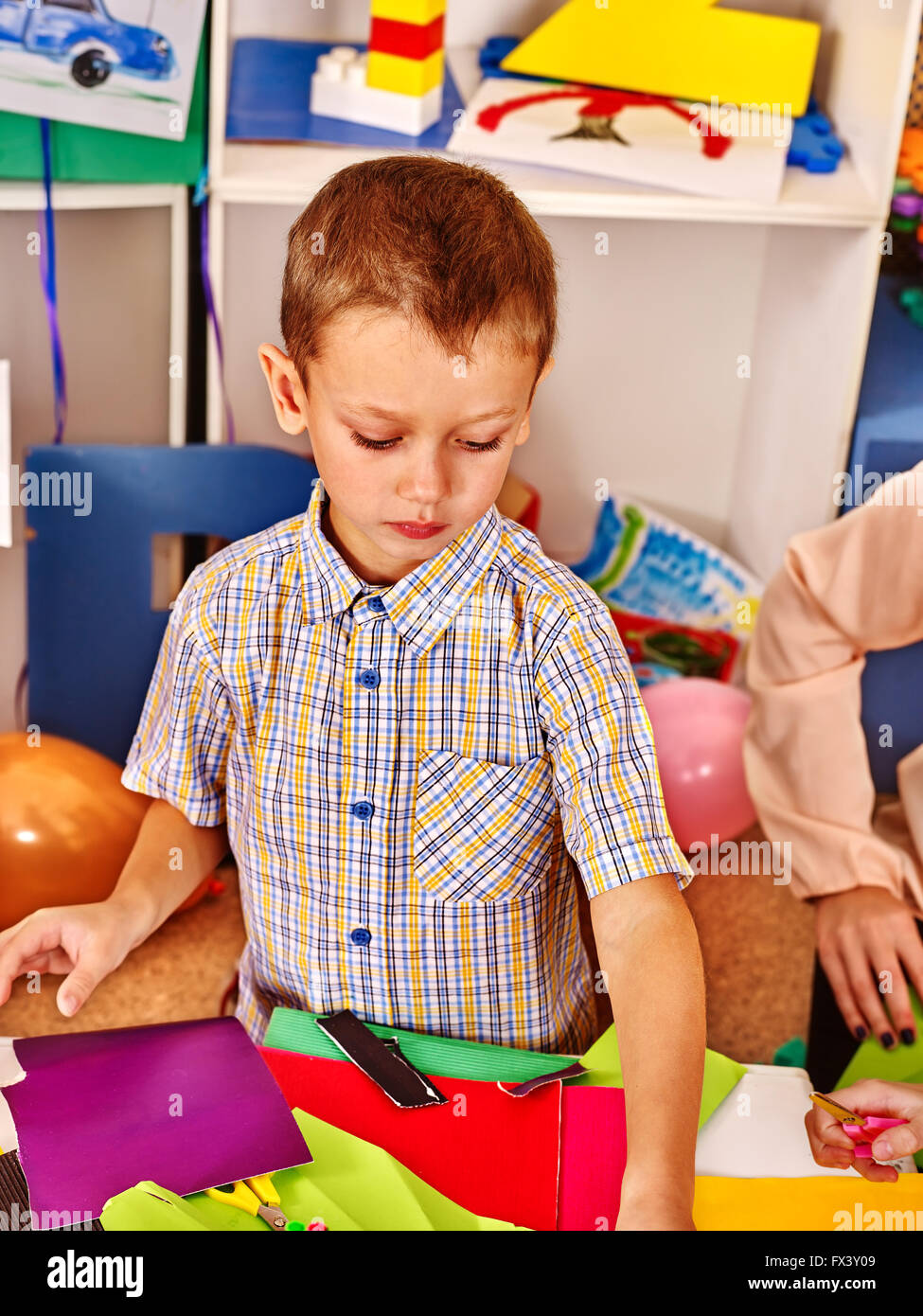 Boy chooses a colored paper Stock Photo - Alamy