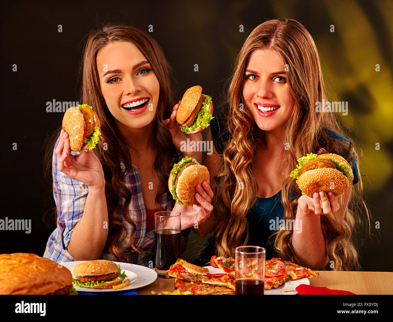 Two girls eating big sandwich Stock Photo - Alamy