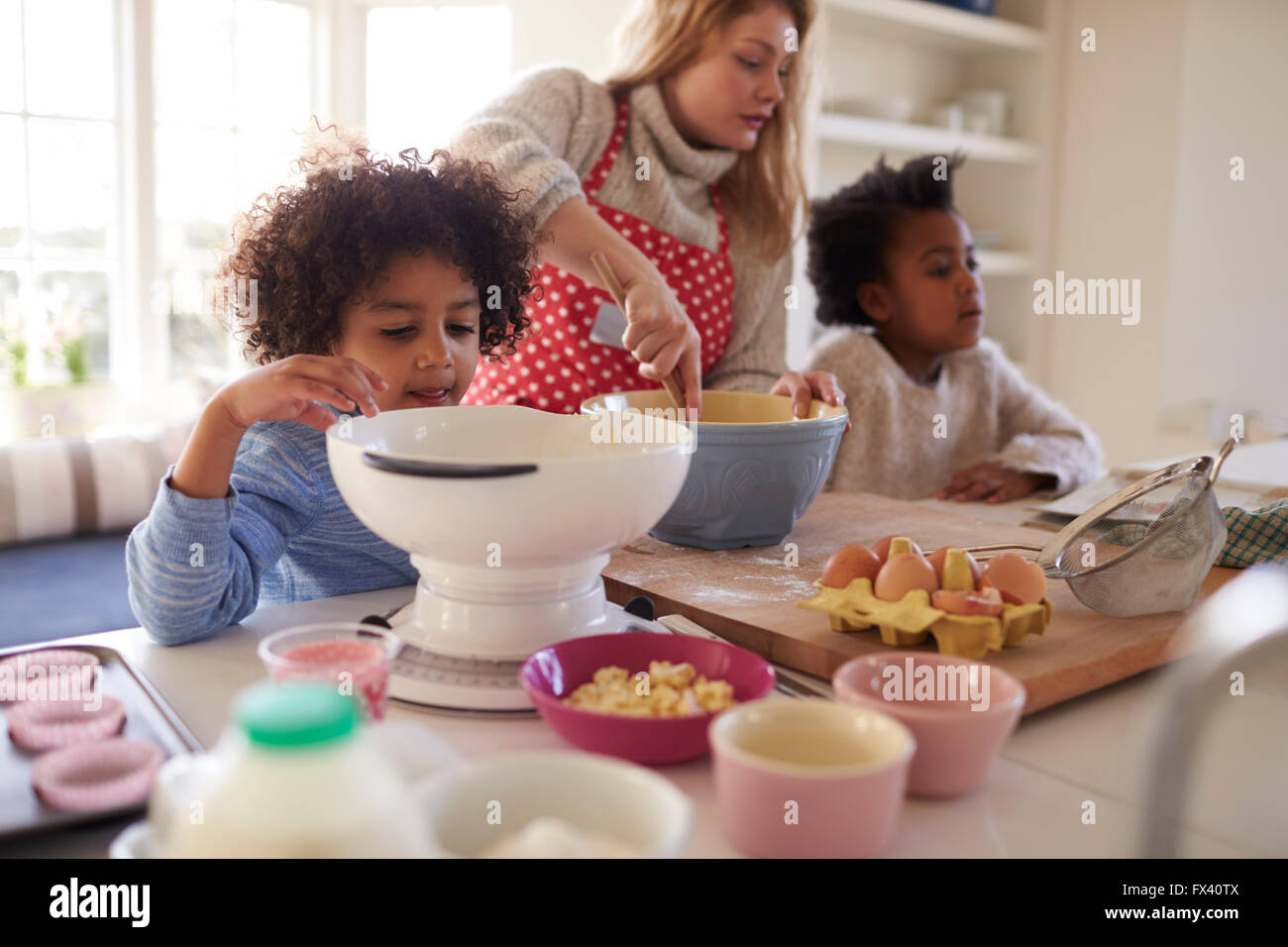 Mother Baking Cake With Children In Kitchen At Home Stock Photo - Alamy