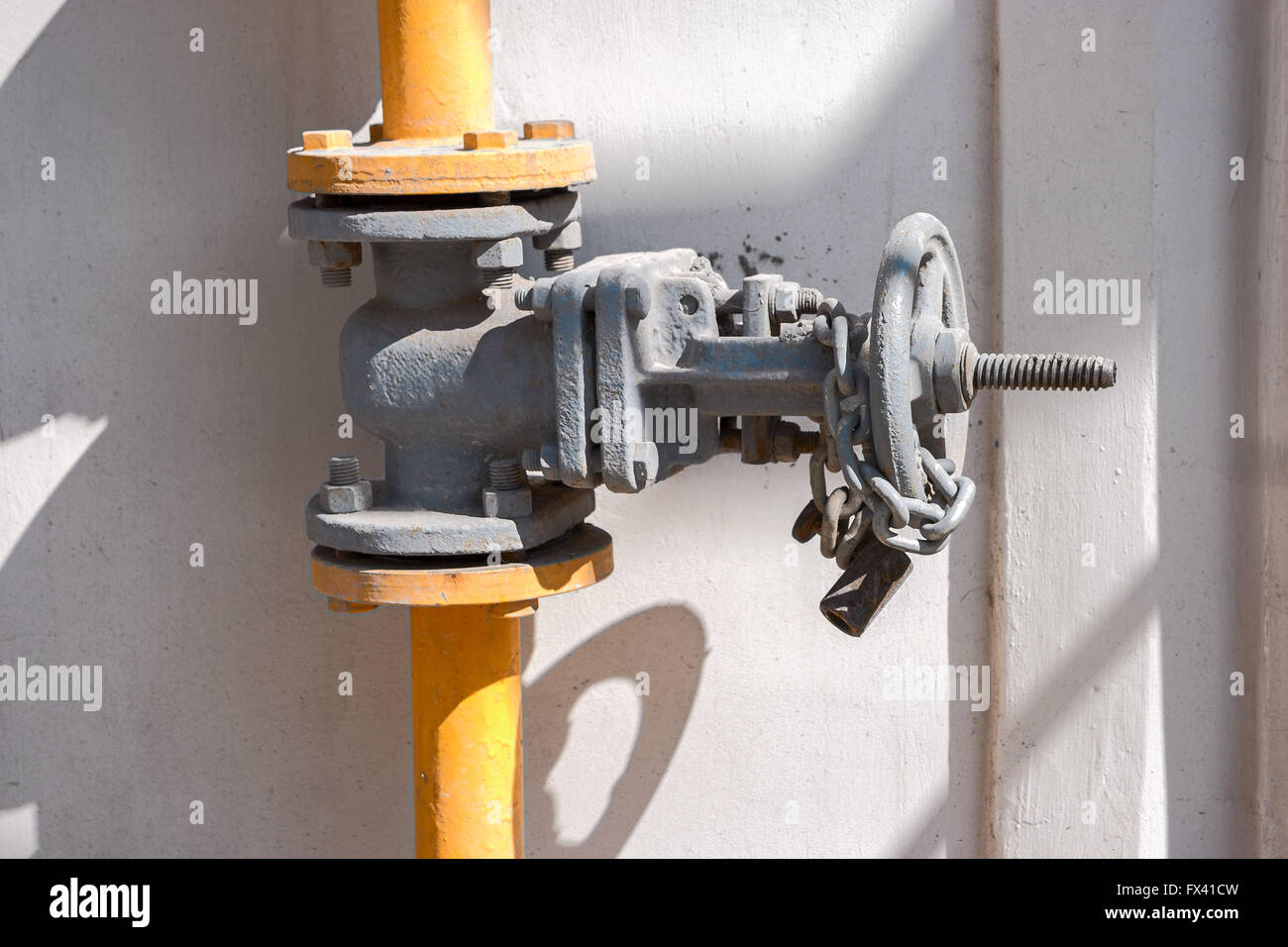 Natural gas valve on steel pipe painted in yellow with shadows Stock ...