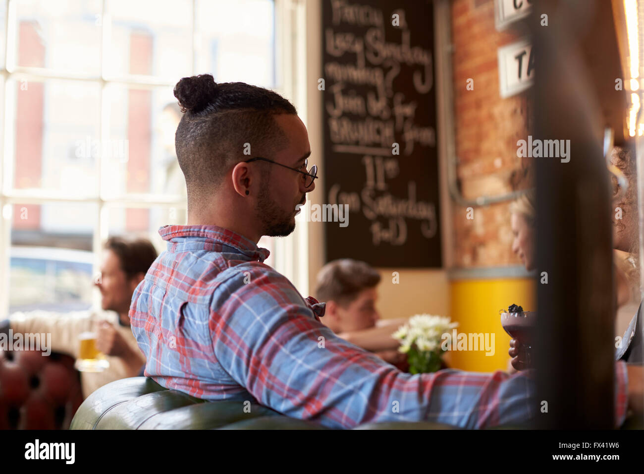 Young Man Enjoying Drink In Busy Cocktail Bar Stock Photo - Alamy