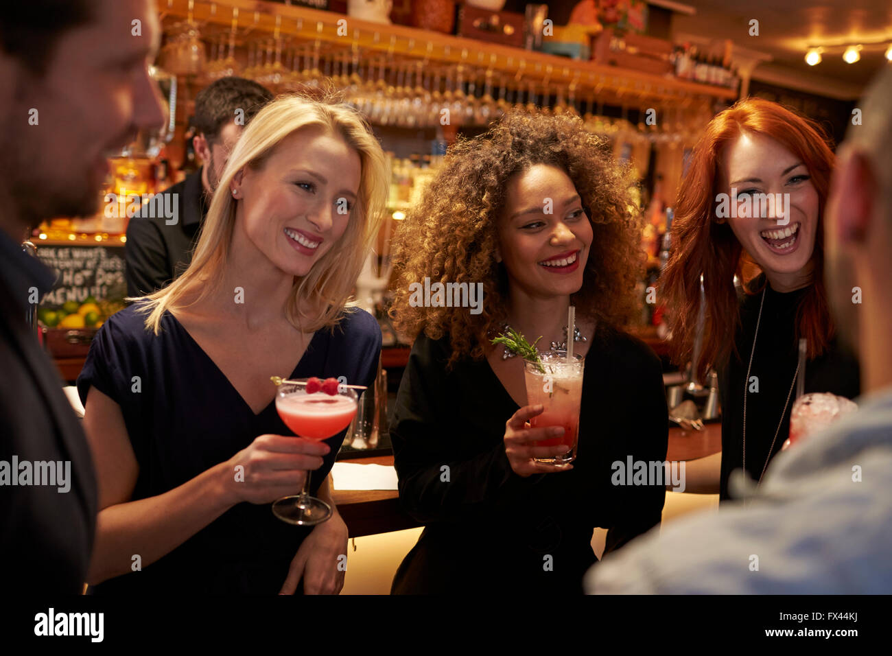 Group Of Friends Meeting For Evening Drinks In Cocktail Bar Stock Photo ...