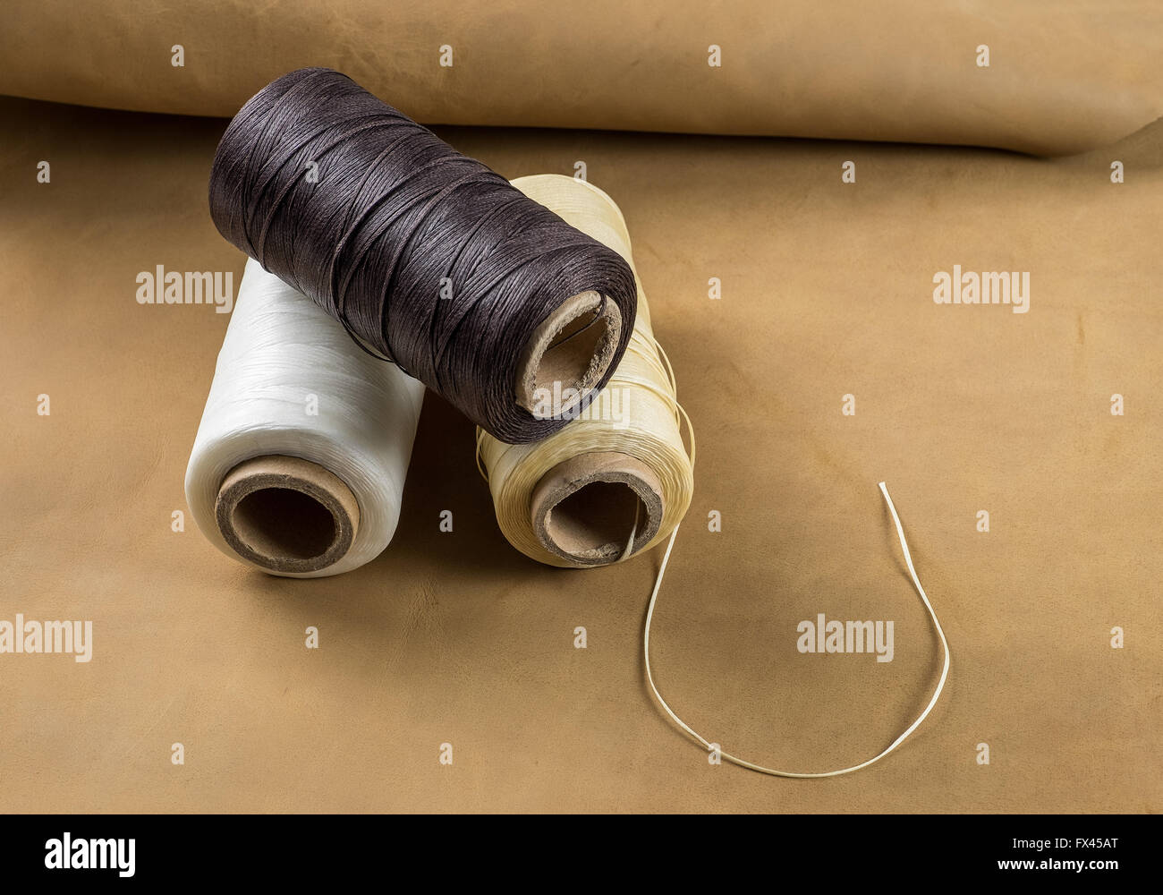 thread for leather crafts, three coils on brown leather Stock Photo - Alamy