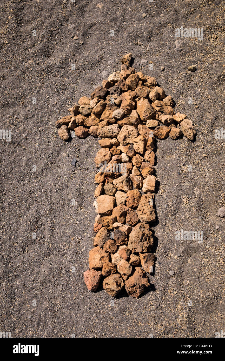 Arrow on the ground made from small stones on a walking route in the ...