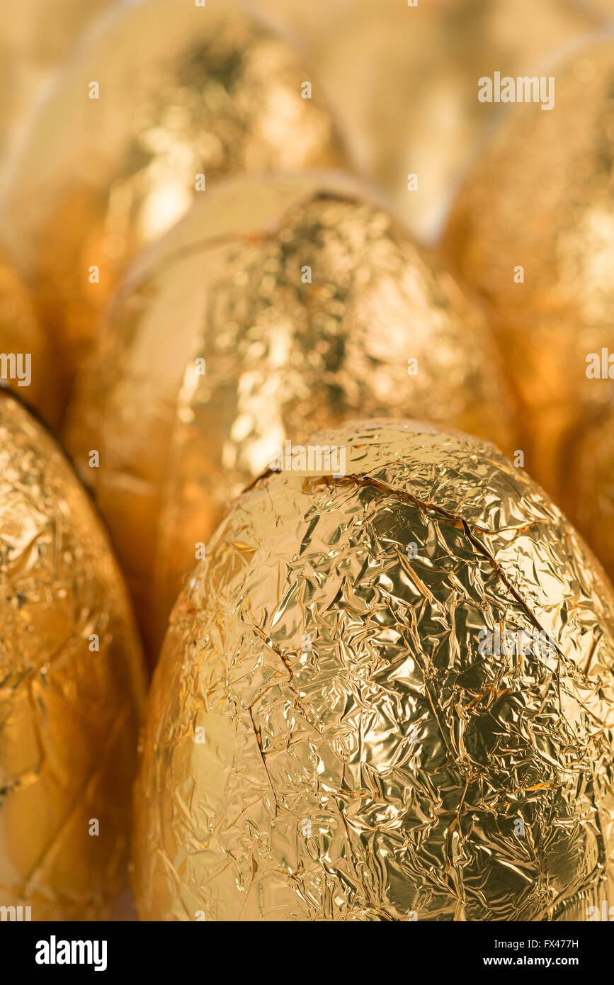 over indulgence in chocolate Easter eggs wrapped up in shiny gold foil ...