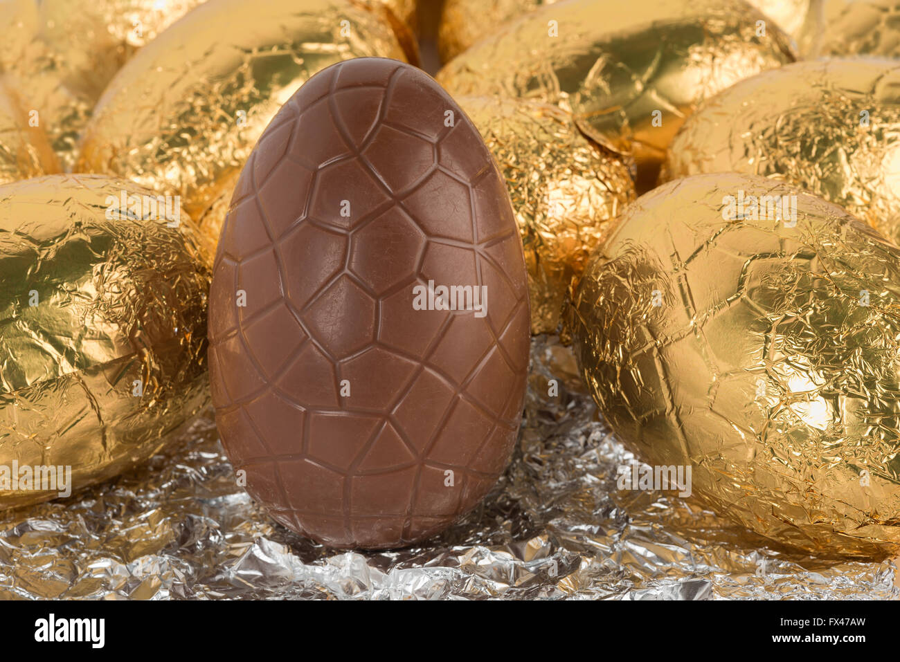 over indulgence in chocolate Easter eggs wrapped up in shiny gold foil ...