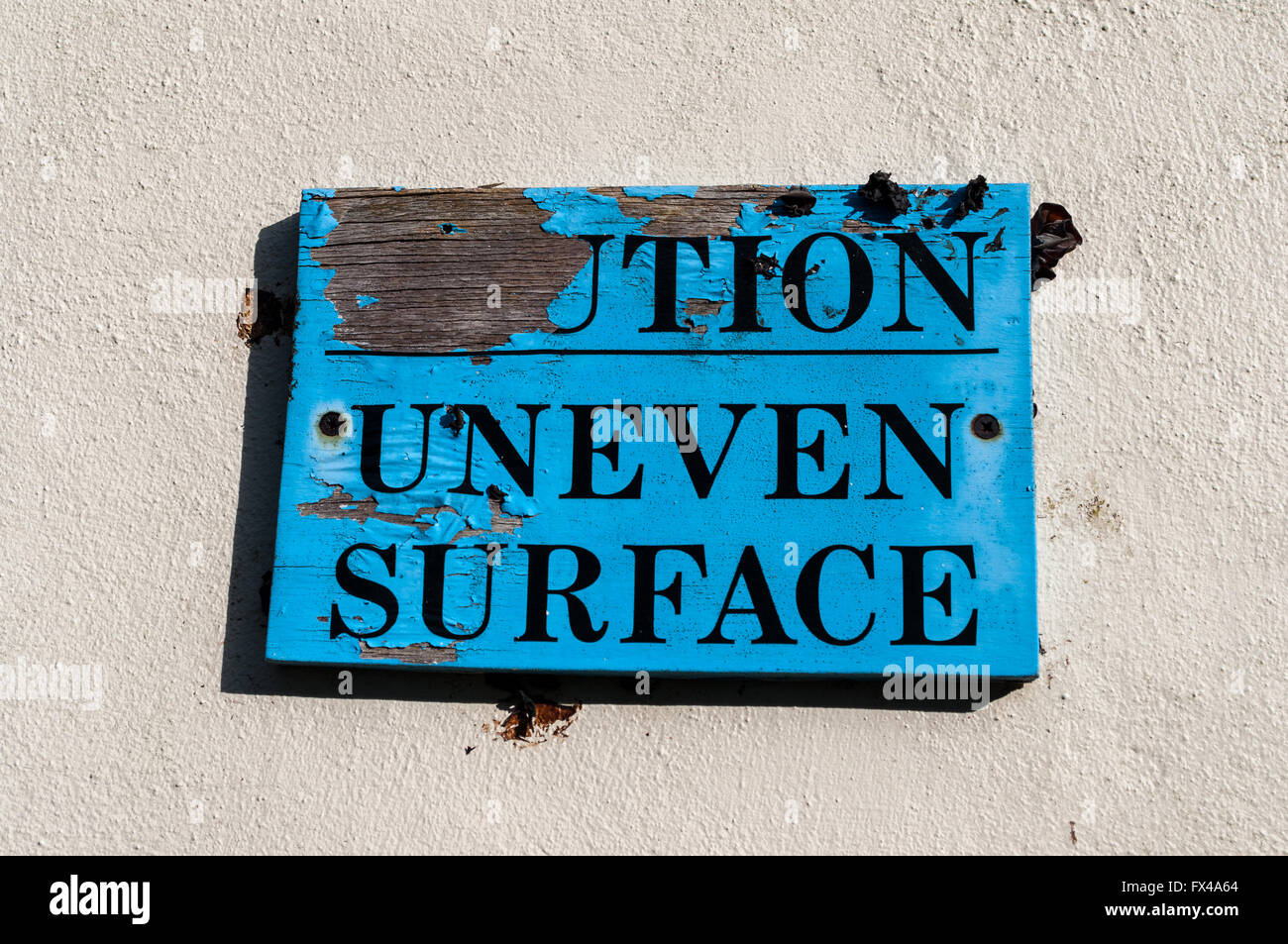 Peeling sign with the words CAUTION UNEVEN SURFACE Stock Photo - Alamy