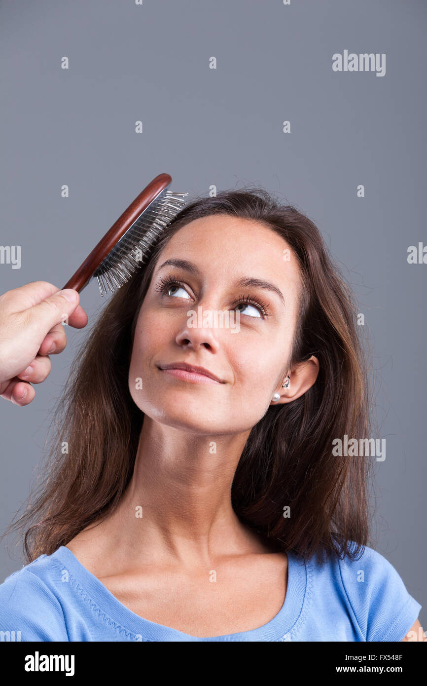 woman pleased by a hand combing her hair with a hairbrush Stock Photo ...