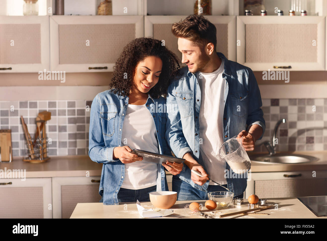 Positive couple cooking together Stock Photo - Alamy