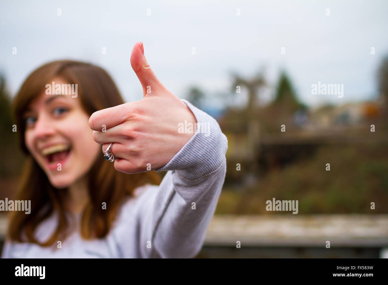 Beautiful girl doing a thumbs up sign with her hand and fingers for ...