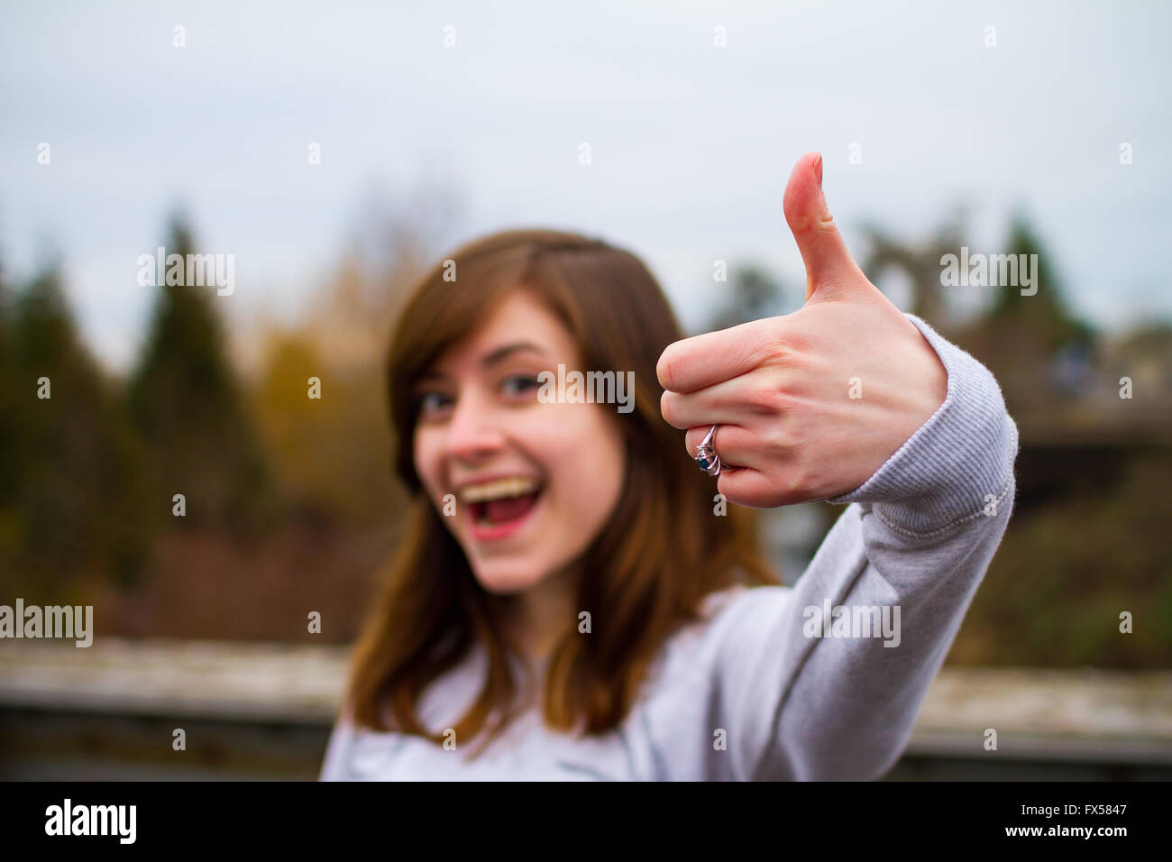 Beautiful girl doing a thumbs up sign with her hand and fingers for ...