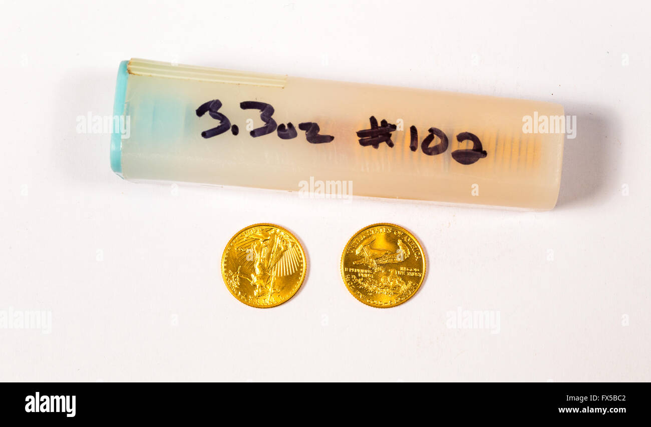 Gold coins in a tube and displayed front and back on white Stock Photo ...