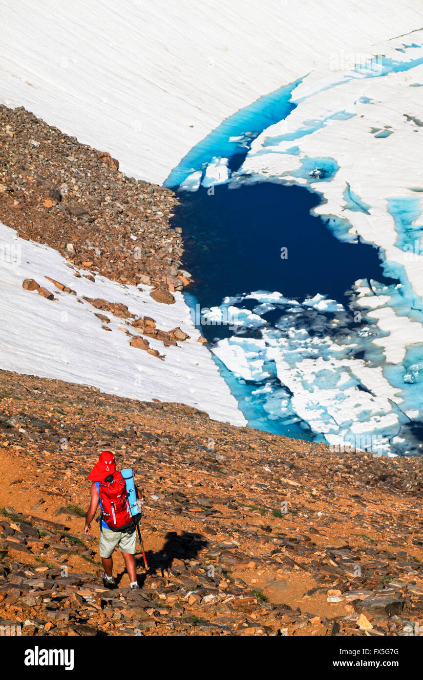 Hiker walking in Sierra Nevada by frozen lagoon, Granada, Spain Stock ...