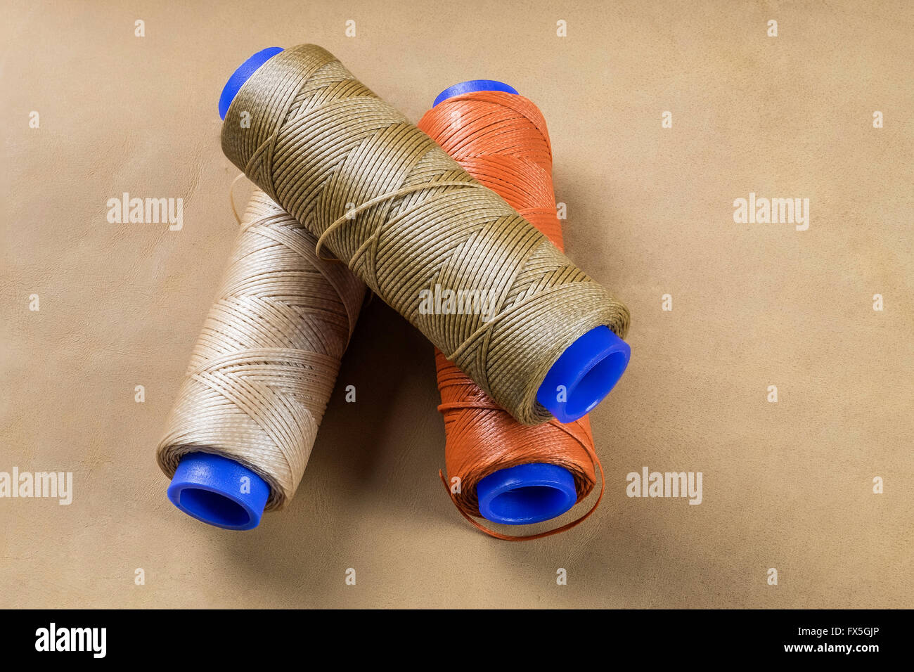 thread for leather crafts, three coils on brown leather Stock Photo - Alamy