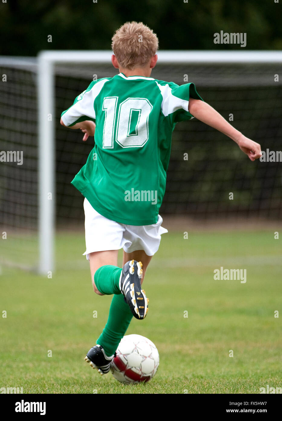 Young man playing soccer seen from the back running with the ball Stock ...