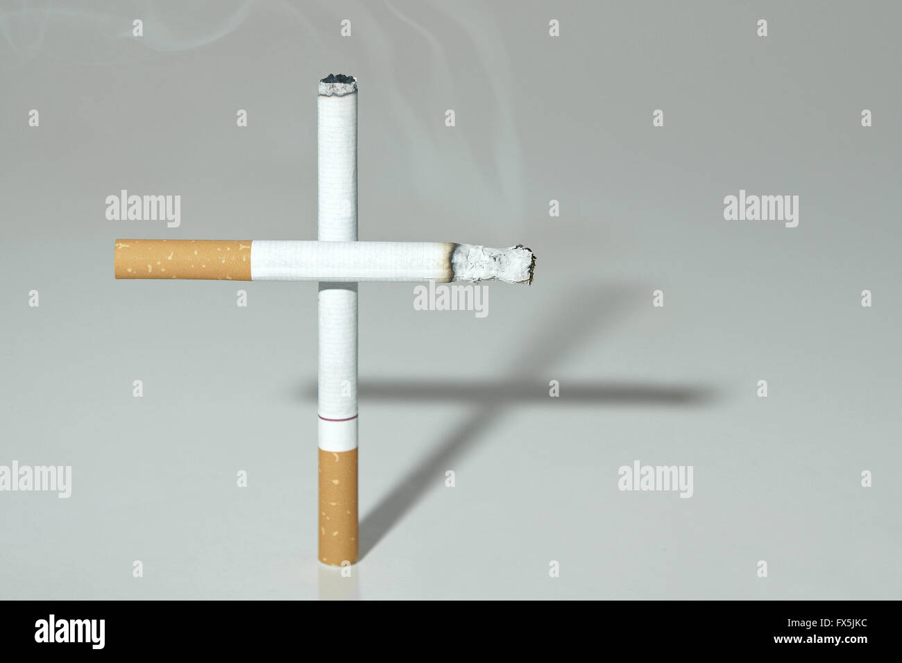 Two cigarettes standing as a cross Stock Photo - Alamy