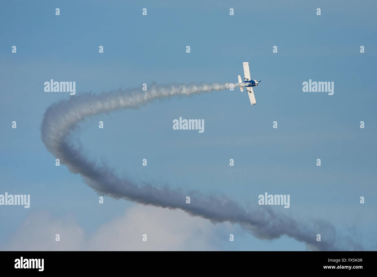 Airplane with smoke and blue skies in the background Stock Photo - Alamy