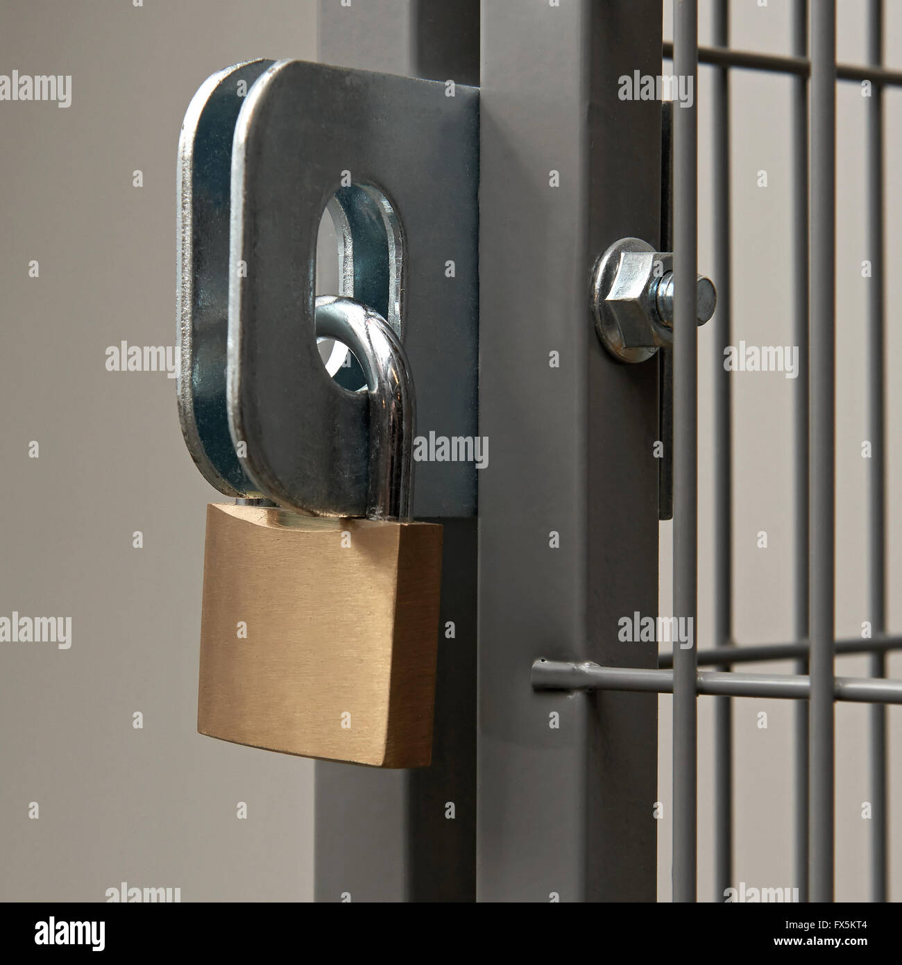 Padlock on a hasp securing a wire fence room Stock Photo - Alamy