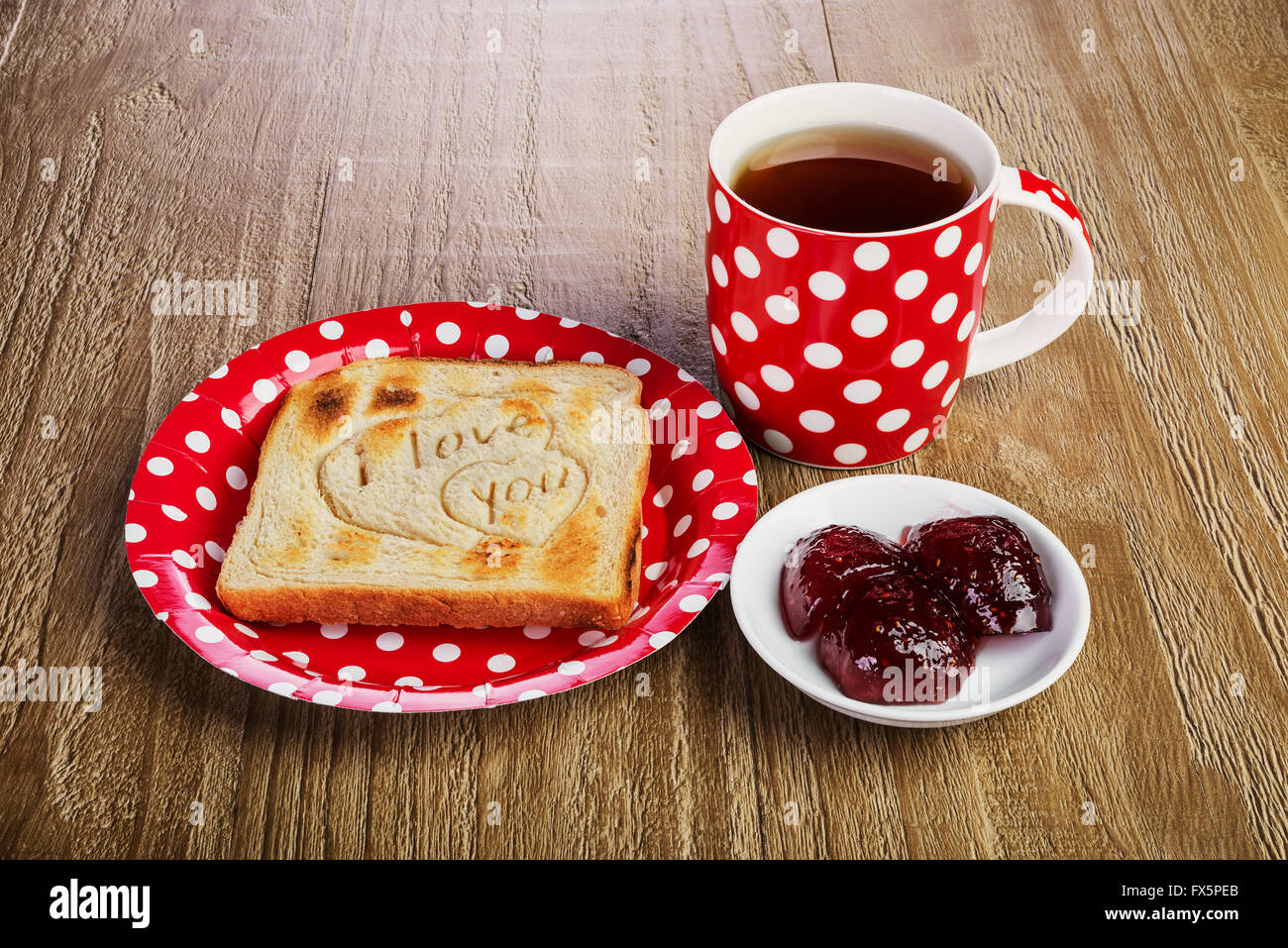 toasted bread with love message and raspberry jam and tea .Breakfast ...