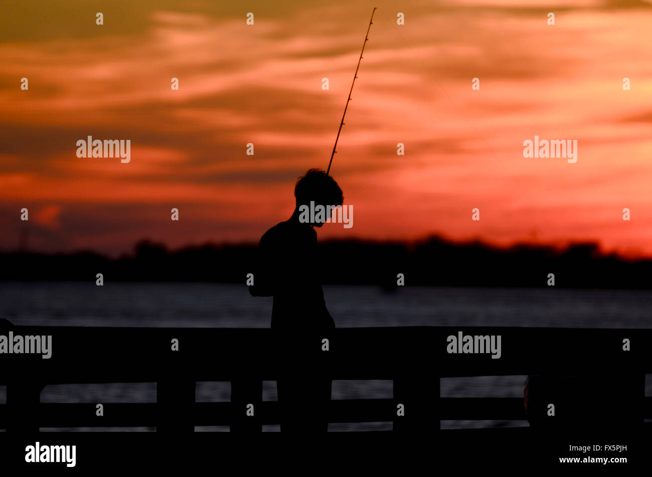Fishing at sunset Stock Photo - Alamy