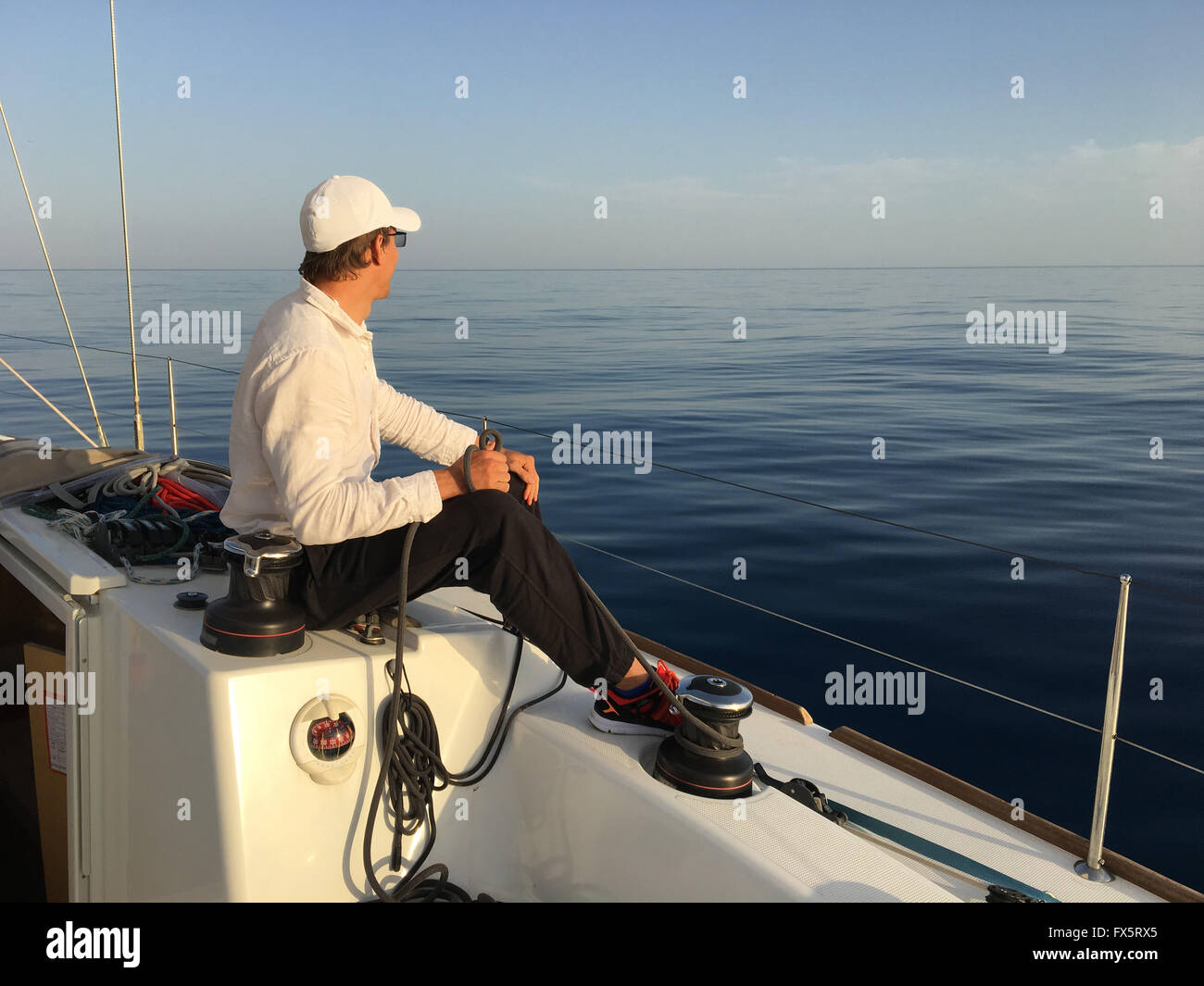 Young man sailing yacht yachtsman holding hands rope Stock Photo - Alamy