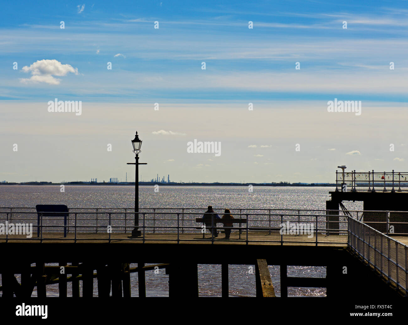 Couple sitting on pier, looking out over the Humber Estuary, Kingston ...