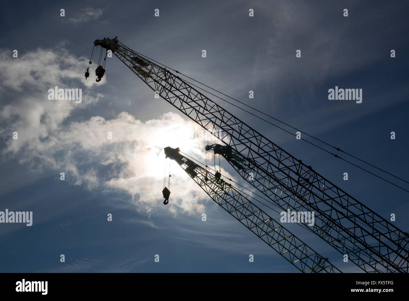 The top of tall crane arms showing the hook and lifting arm on a ...
