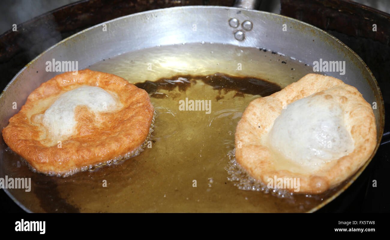 two italian traditional sweet pastry frying in very hot oil Stock Photo ...