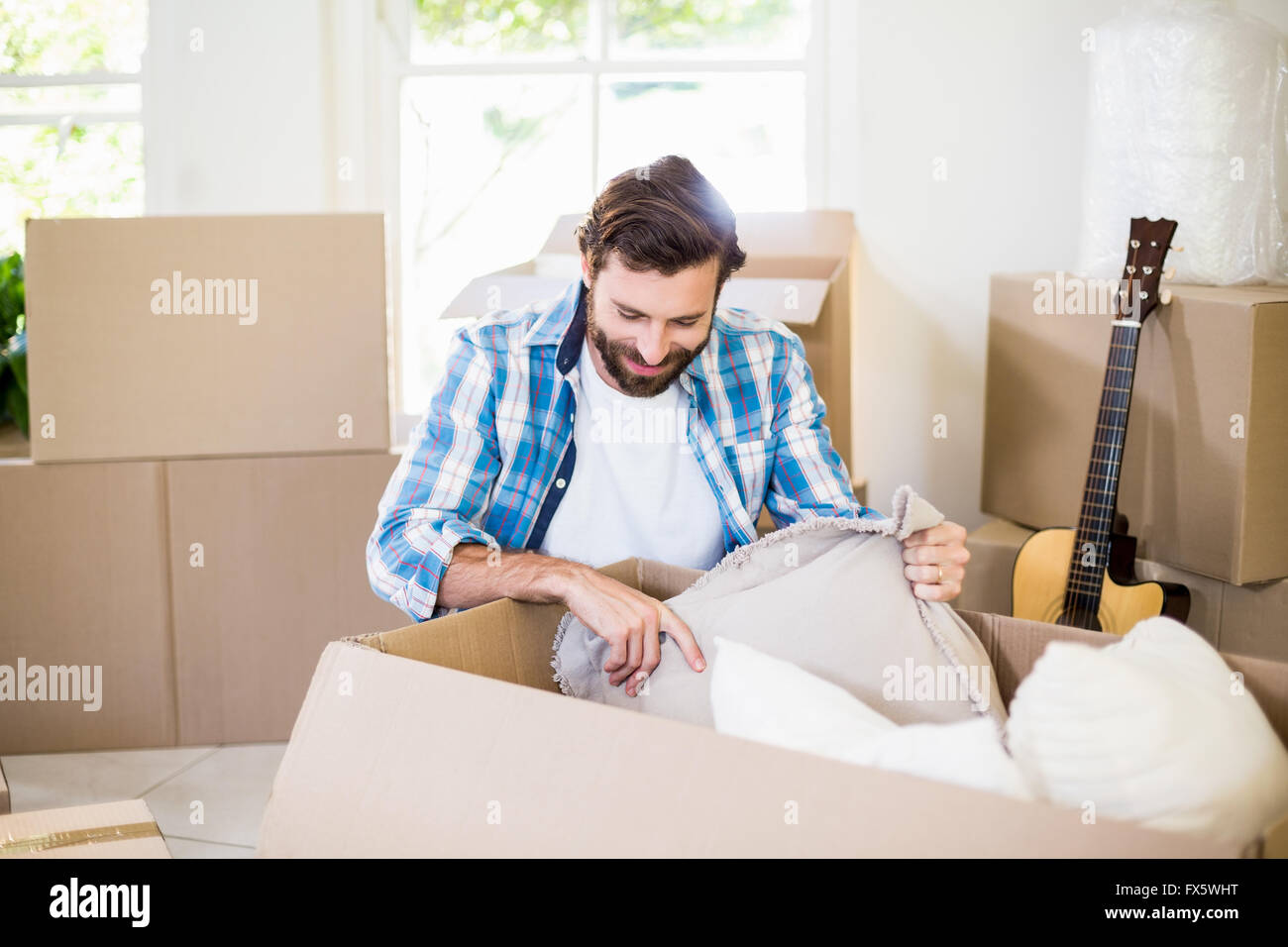 Young man unpacking carton boxes Stock Photo - Alamy