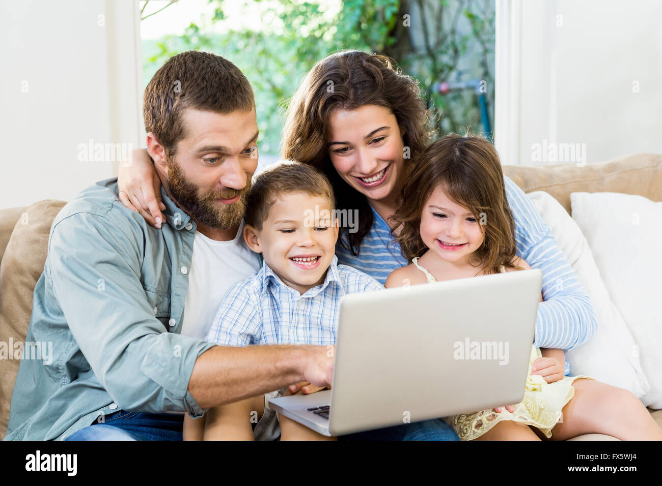 Smiling family with laptop Stock Photo - Alamy