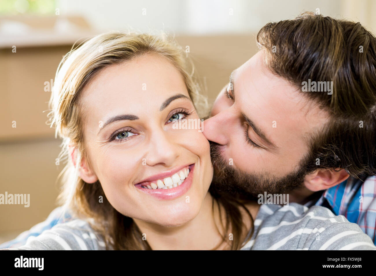 Young man kissing on womans cheek Stock Photo - Alamy
