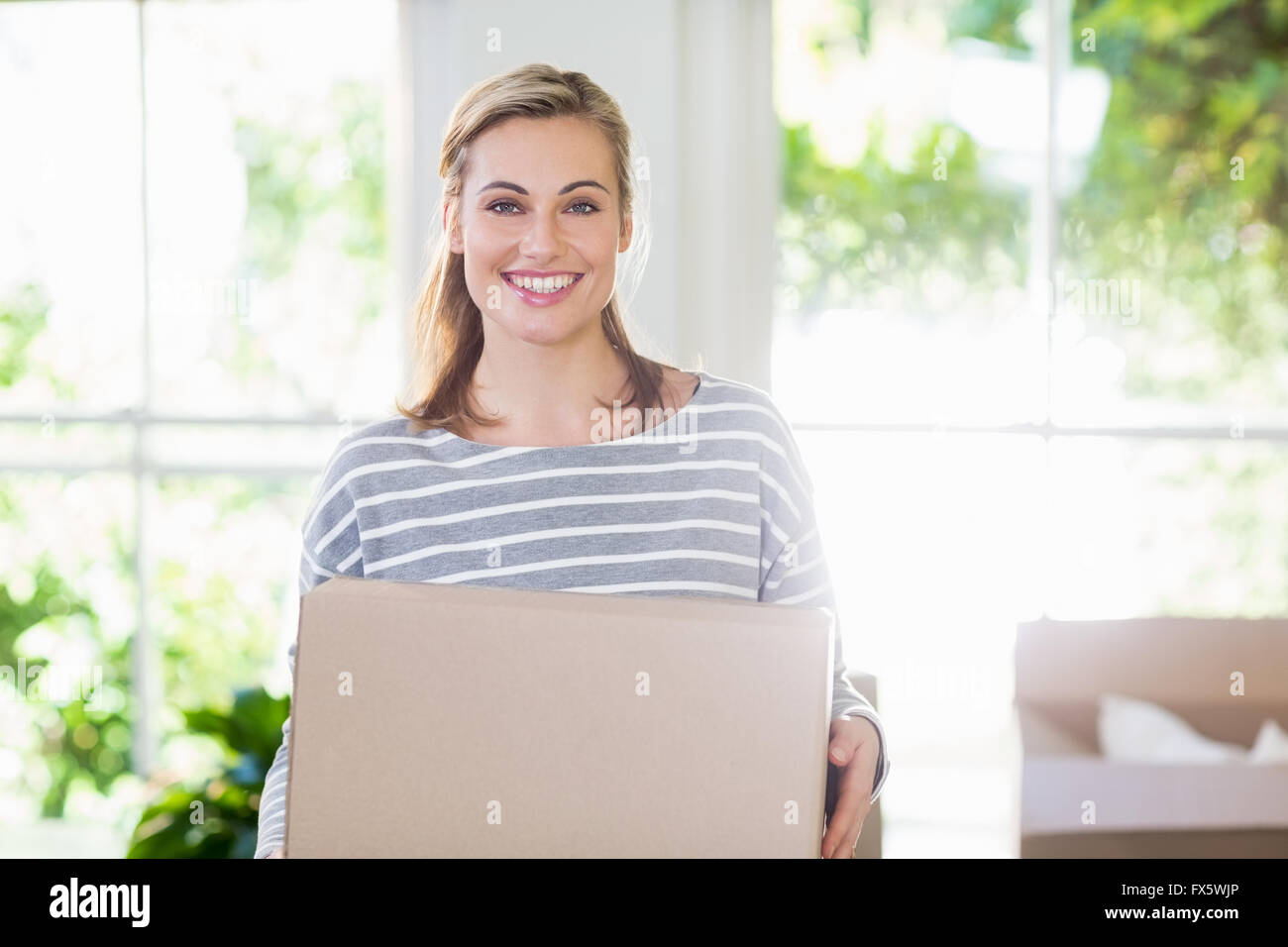 Portrait of young woman holding cardboard boxes Stock Photo - Alamy