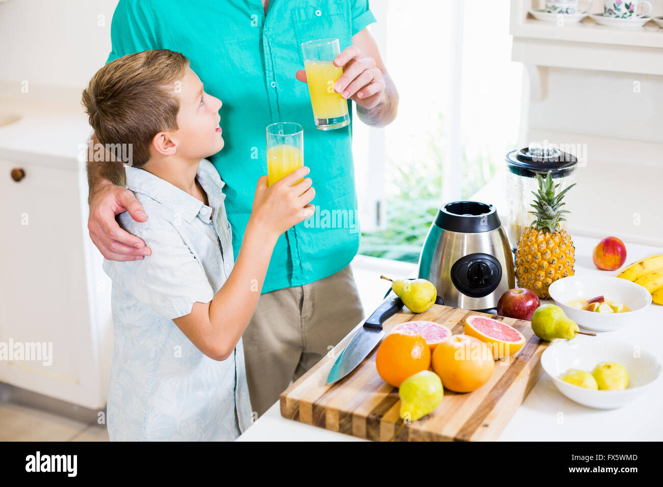 Father and son holding glass of a juice Stock Photo - Alamy