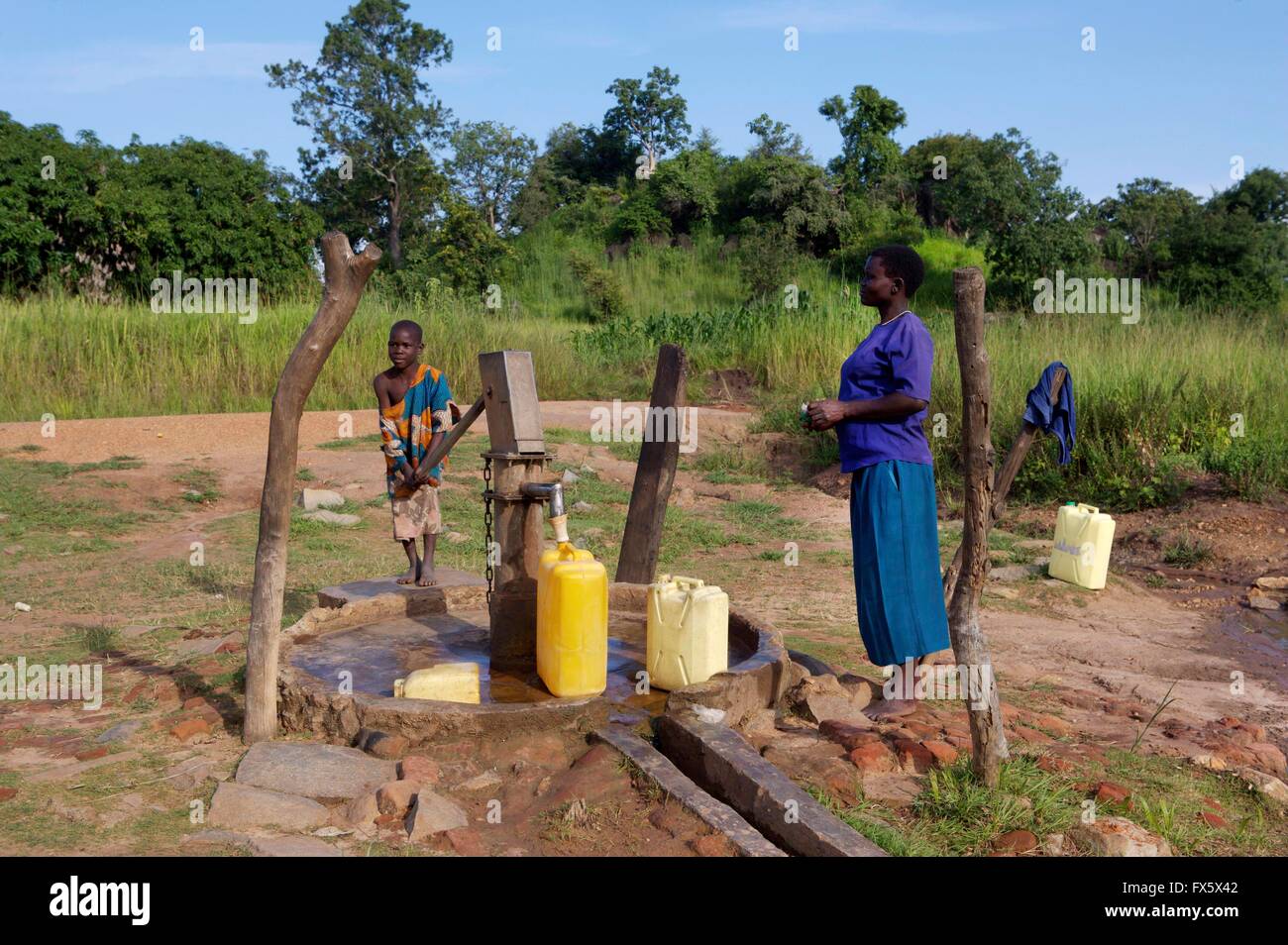 Mother and daughter gathering water from a well in Uganda, Africa Stock ...