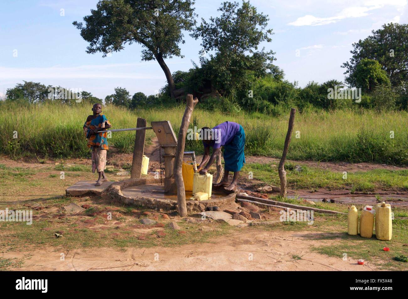 Mother and daughter gathering water from a well in Uganda, Africa Stock ...